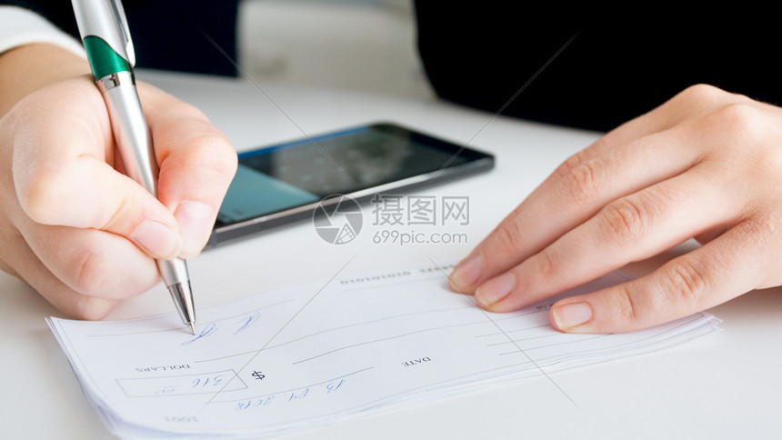 在银行支付票上签字的女商人近照高清图片下载-正版图片304746263-摄图网