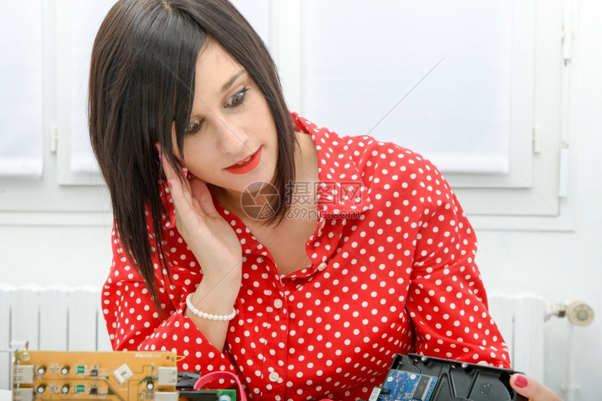 年轻笑着的黑发女人修理电脑的技术师高清图片下载-正版图片307219234-摄图网