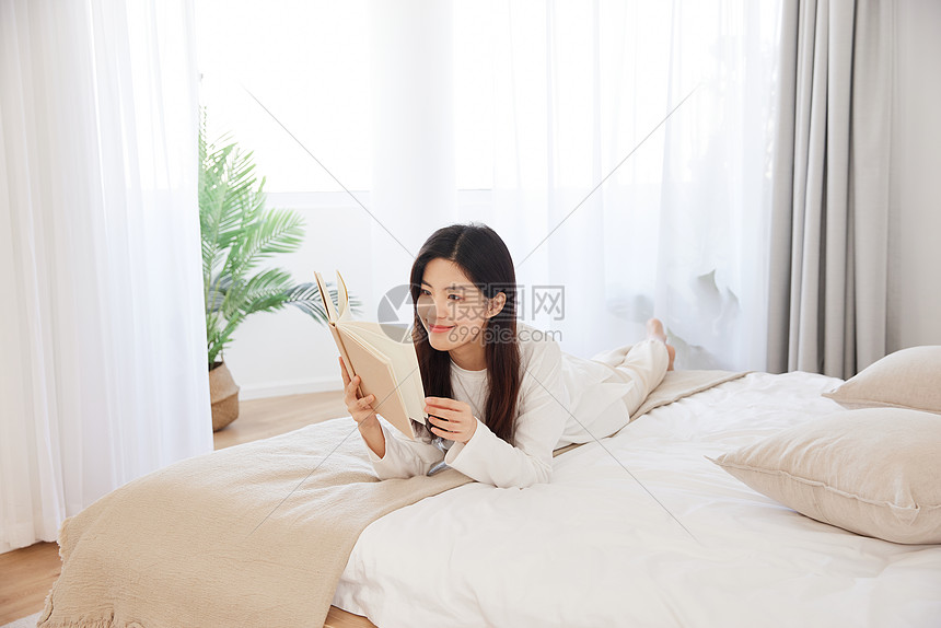 趴在床上看书的年轻女孩高清图片下载 正版图片501721970 摄图网