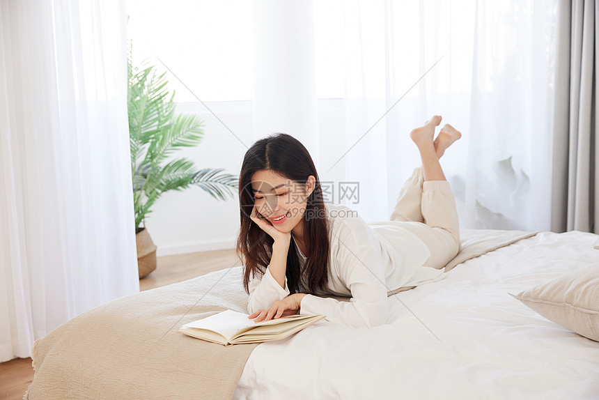 趴在床上看书的年轻女孩高清图片下载 正版图片501721972 摄图网