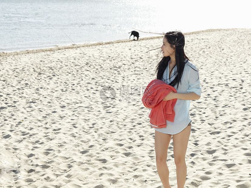 澳大利亚维多利亚州墨尔本港年轻女子拿着沙滩巾在海滩上散步高清图片下载 正版图片501844539 摄图网