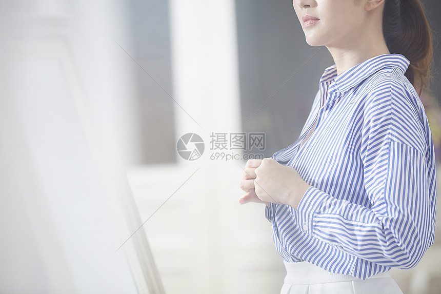 扣上衬衫扣子的年轻女子高清图片下载-正版图片502184986-摄图网