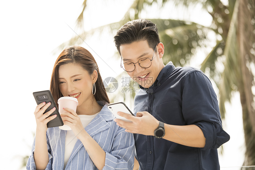 户外看着手机的青年男女高清图片下载-正版图片502321185-摄图网