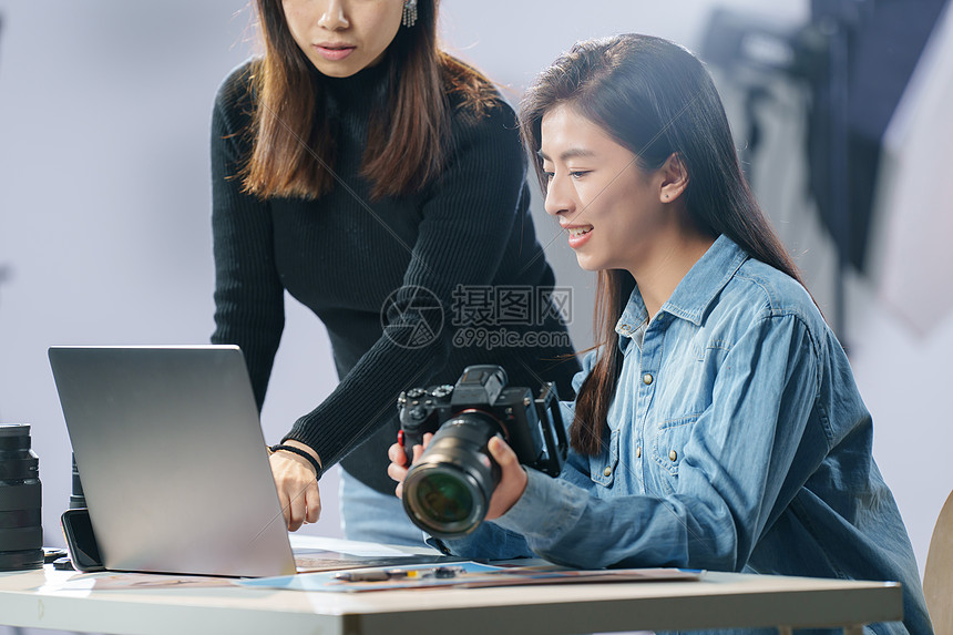 在工作室里讨论工作的青年女摄影师高清图片下载-正版图片502475022-摄图网