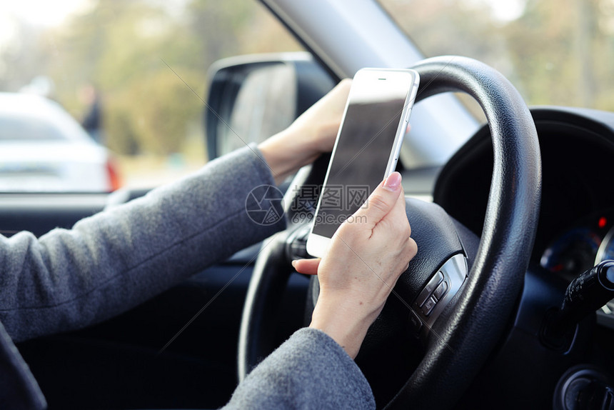 驾驶汽车的司机看着手机高清图片下载-正版图片502521354-摄图网