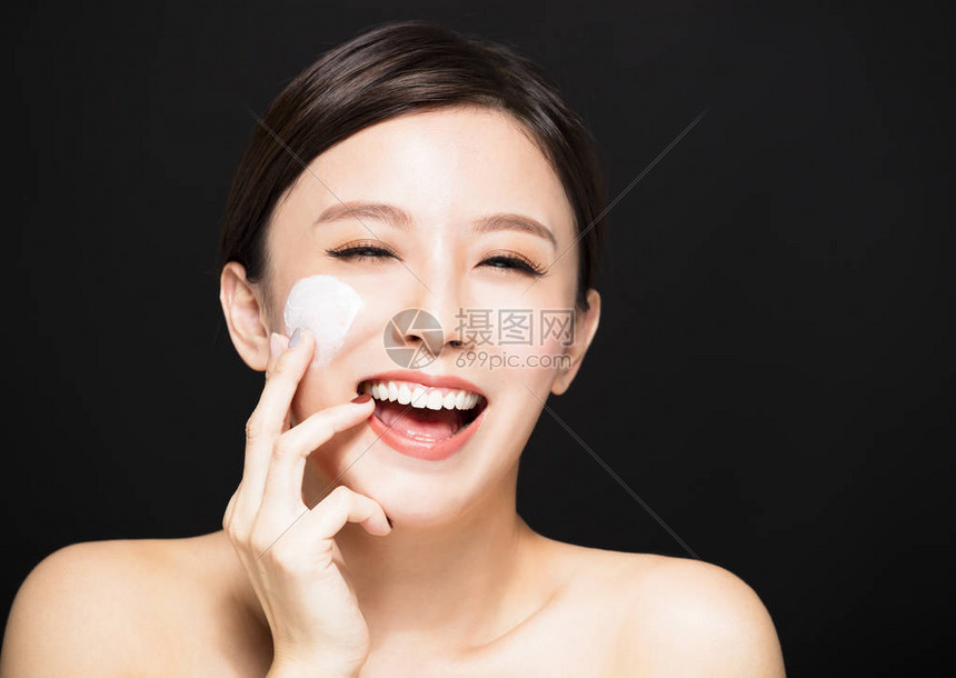 快乐的女人在脸上涂乳液霜高清图片下载 正版图片502527854 摄图网
