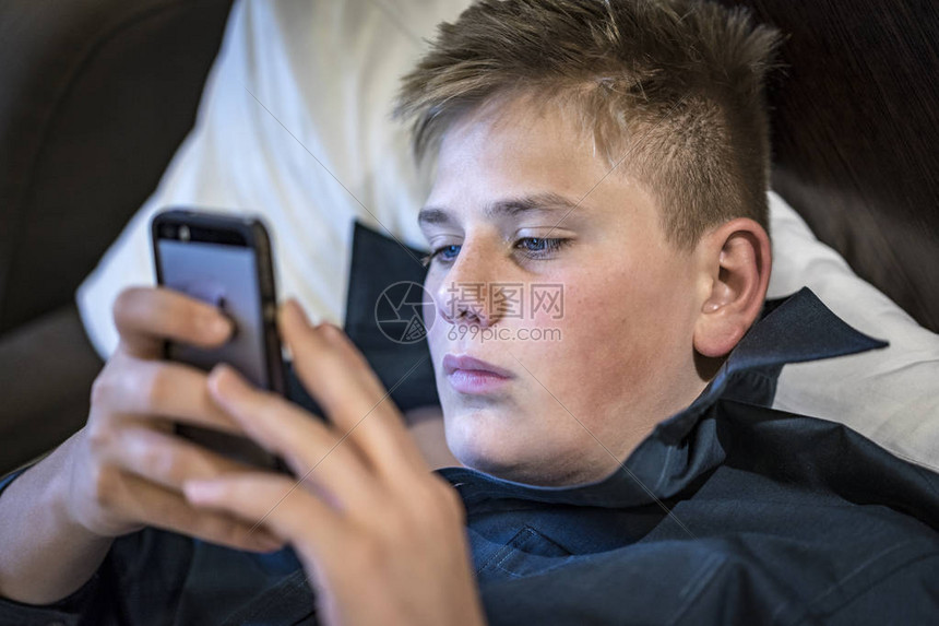 年轻少年男孩在他的手机上读短信高清图片下载 正版图片502677002 摄图网