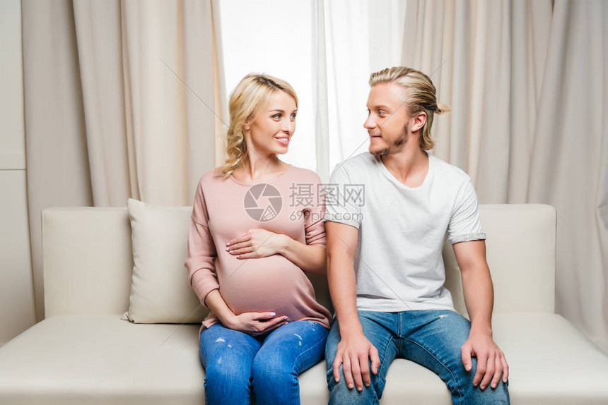 幸福的怀孕夫妇一起坐在沙发高清图片下载-正版图片502697029-摄图网