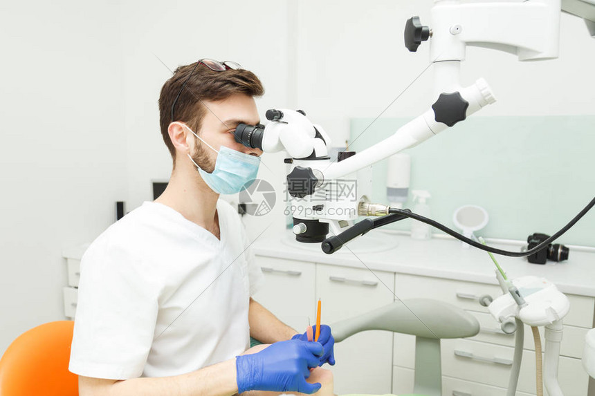 男牙医正在通过显微镜观察高清图片下载-正版图片502708812-摄图网