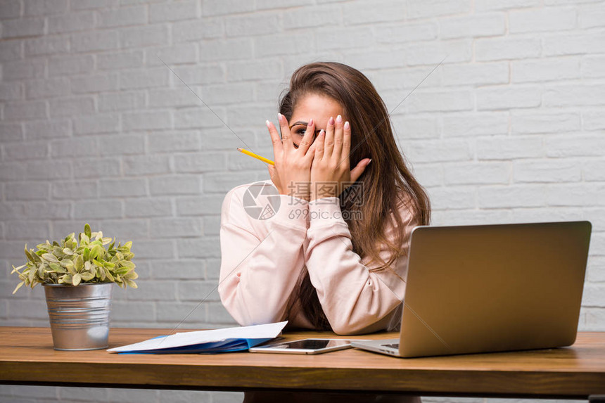 坐在办公桌边的年轻学生拉丁女人的肖像感高清图片下载 正版图片502800584 摄图网