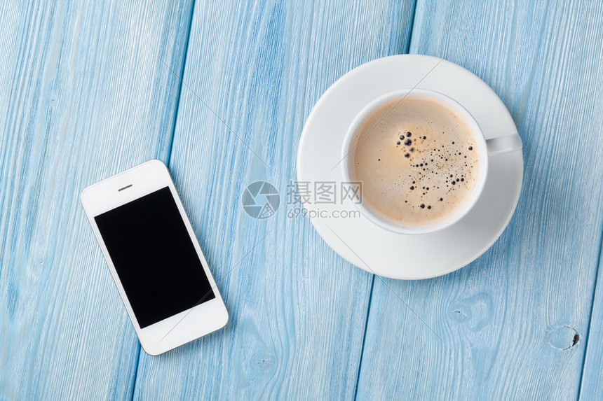 木桌背景的咖啡杯和智能手机顶视图高清图片下载-正版图片502810435-摄图网