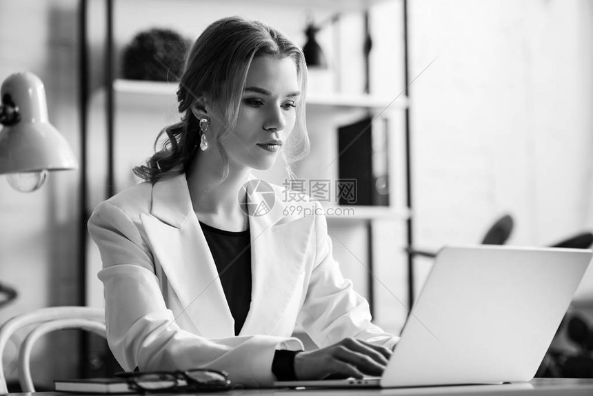 正式女商人坐在办公桌上和在工作场所笔记本电脑上打字时身穿正高清图片下载 正版图片502848771 摄图网