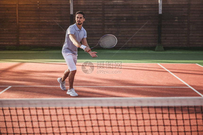 英俊的男人正在户外网球场打网球高清图片下载-正版图片502905270-摄图网