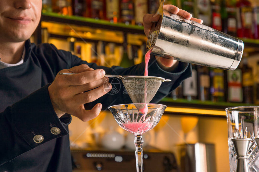 迷人的调酒师准备美味的鸡尾酒通过滤器过滤饮料并倒高清图片下载-正版图片503556404-摄图网