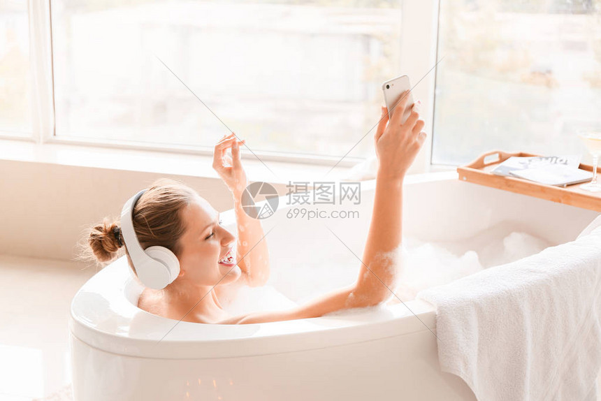 美丽的年轻女子在家洗澡时听音高清图片下载 正版图片503607097 摄图网