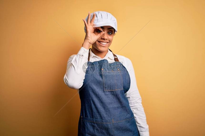 年轻的非洲裔美国黑人面包师女人穿着围裙和帽子在黄色背景上做着很好的手势高清图片下载-正版图片503683028-摄图网