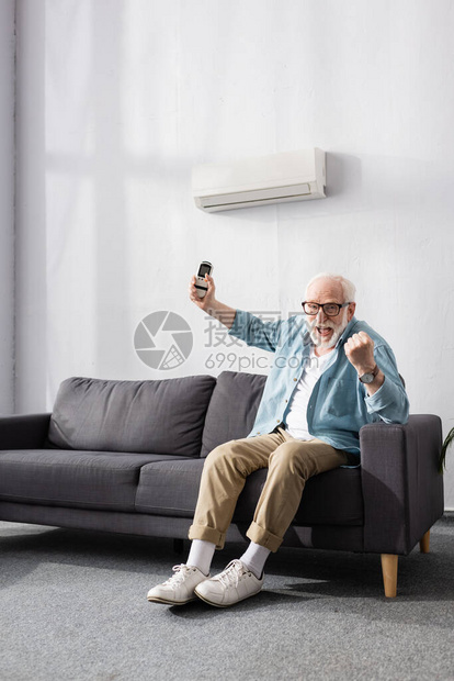 在沙发上摆出一副好意的姿势坐在沙发上举着一个很高清图片下载 正版图片503860622 摄图网