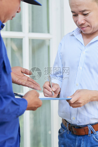 男子与邮差站在一起并签署一份将包裹送高清图片下载-正版图片503873245-摄图网