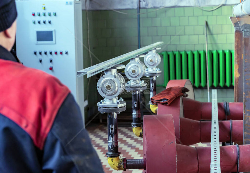 Fitter装配机正在一个煤气锅炉房内装设一条新高清图片下载-正版图片504005842-摄图网