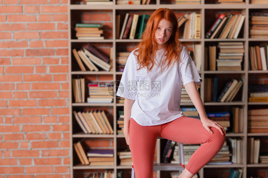 红发女大学生从图书馆的书架上取书高清图片下载 正版图片504045193 摄图网