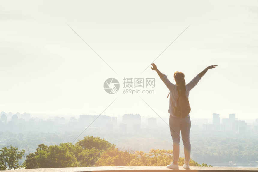 在城市全景的背景下张开双臂的女人高清图片下载-正版图片504069045-摄图网