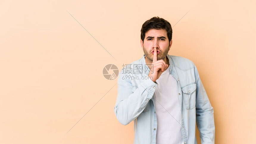 年轻人在米色背景上被隔离保守秘密或要求保持沉默高清图片下载-正版图片504080195-摄图网