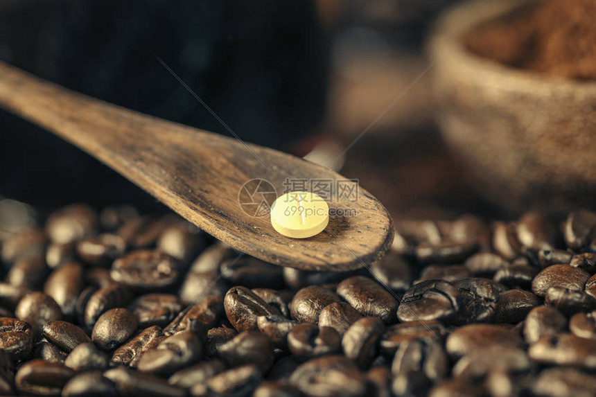 木勺中的咖啡因丸烤咖啡豆一杯黑咖啡和背景木碗高清图片下载-正版图片504106695-摄图网