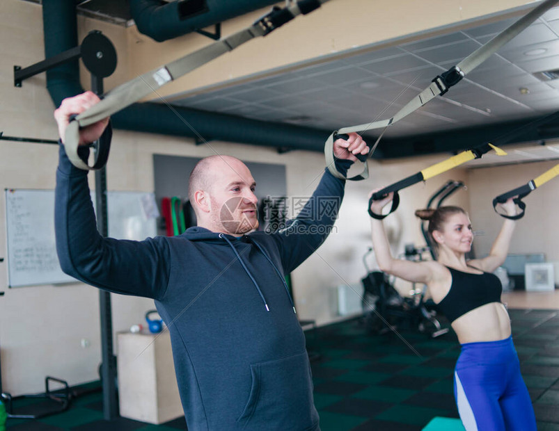 男女在健身房用健身带锻炼运动时可以接受高清图片下载-正版图片504510702-摄图网
