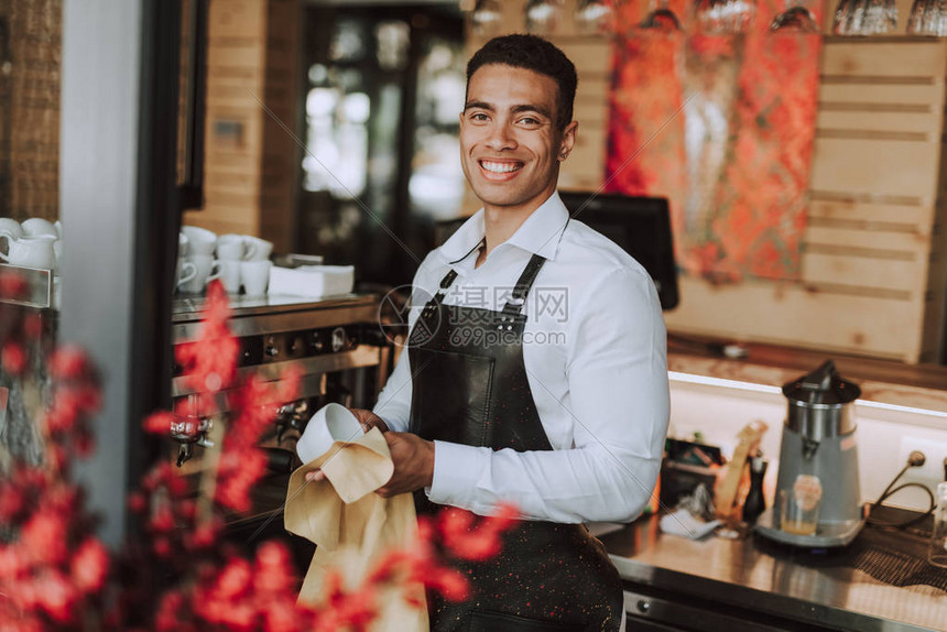 英俊的调酒师在黑色围裙清洁杯咖啡在咖啡厅的腰部肖像他高清图片下载-正版图片504537247-摄图网