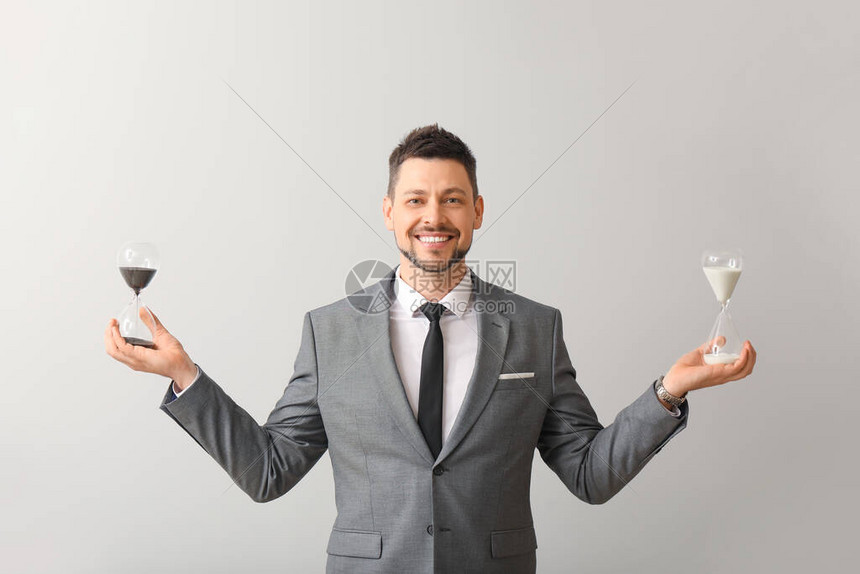 光背景有沙眼的商人时间管理概念高清图片下载-正版图片504548898-摄图网