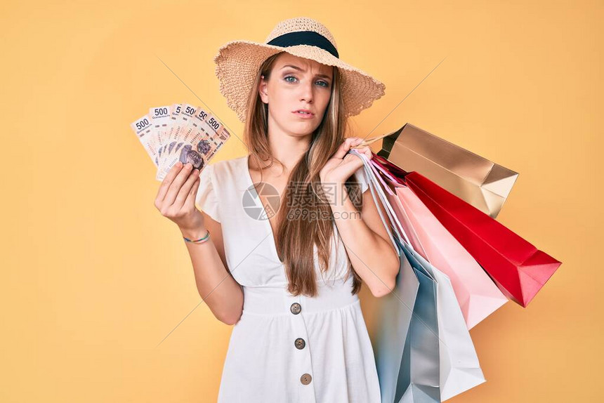 年轻金发女孩拿着购物袋和墨西哥比索的钞票高清图片下载 正版图片504563961 摄图网