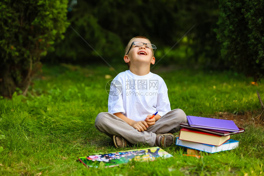 可爱的男生在明亮的秋日户外学习男孩戴着眼镜看书回到学校做家庭作业的年轻学生高清图片下载-正版图片504574452-摄图网
