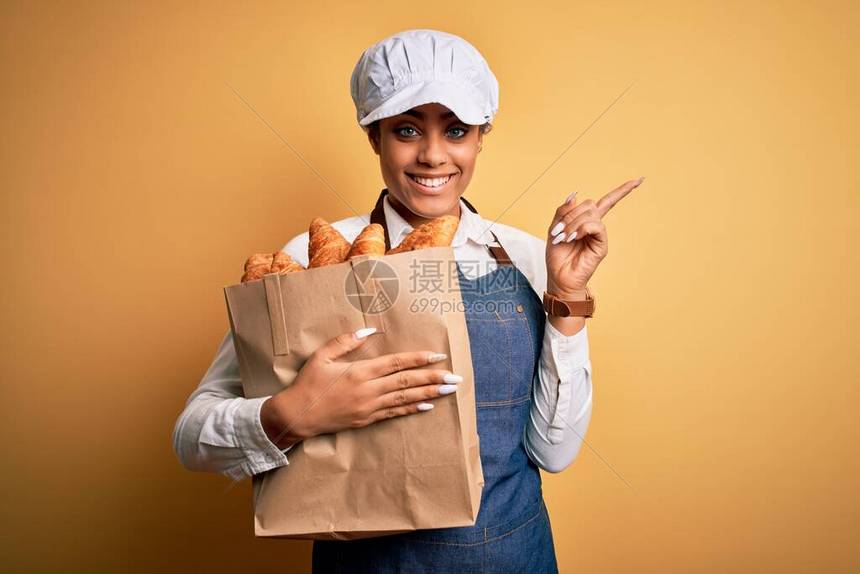 身着围裙的非洲年轻面包师女孩与法国羊角面包师一起高清图片下载-正版图片504611932-摄图网
