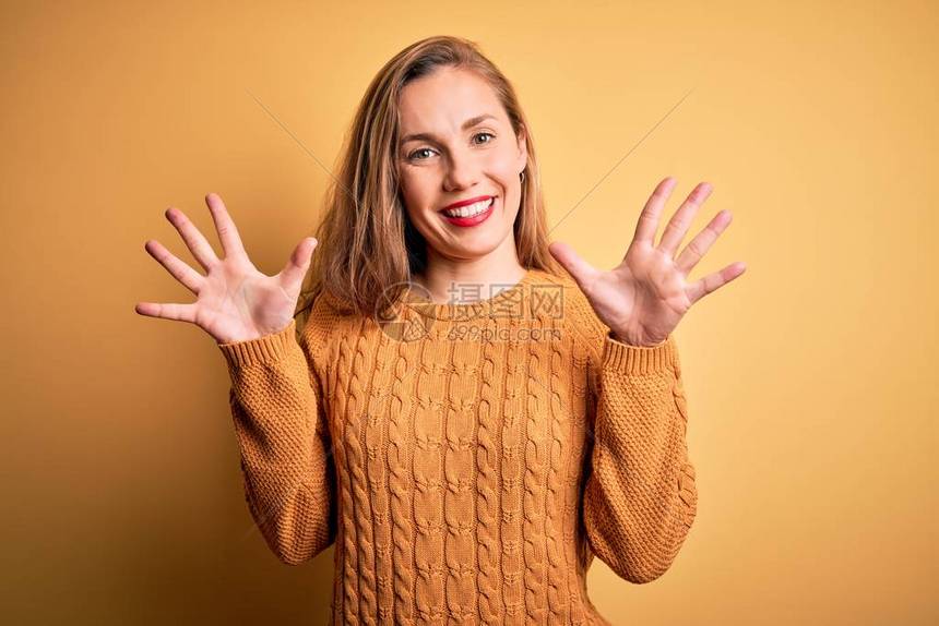 年轻漂亮的金发女郎穿着休闲毛衣站在黄色背景上高清图片下载 正版图片504621749 摄图网