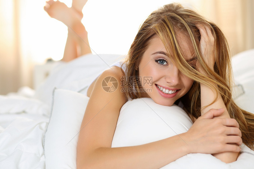 年轻美丽的金发微笑女人肖像在睡觉和躺在床上看着相机后清晨醒来高清图片下载 正版图片504899444 摄图网
