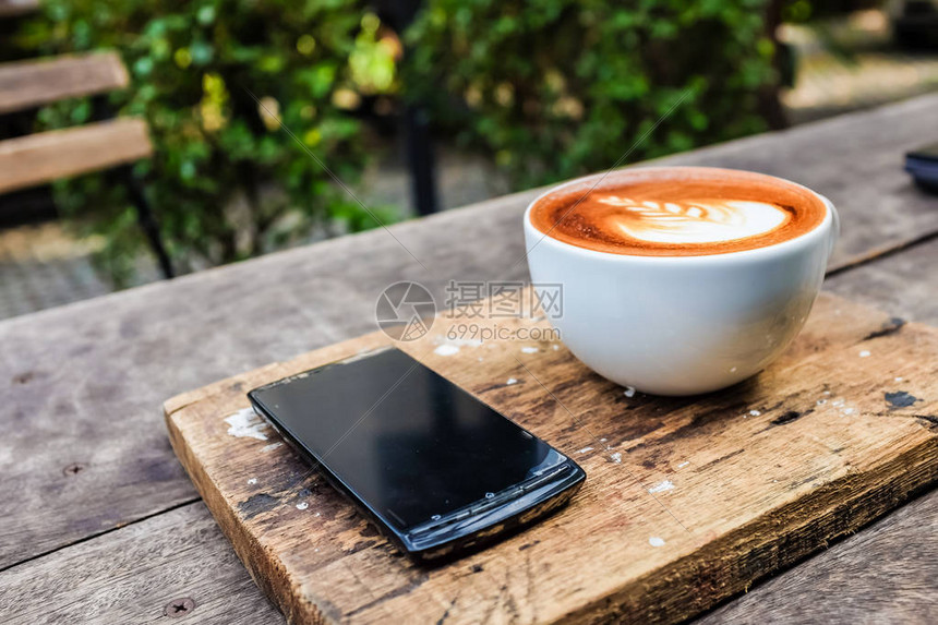 手持拿铁的移动电话咖啡杯和木高清图片下载-正版图片504979634-摄图网