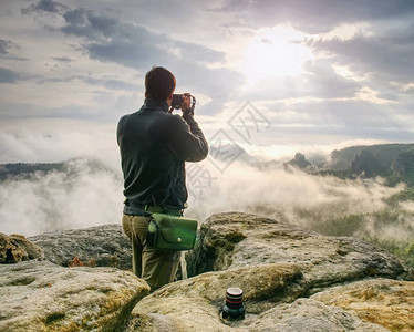 摄影师用取景器取景摄影爱好者在岩石山顶享受秋季大自然的作品梦幻般的风景高清图片下载-正版图片505043932-摄图网