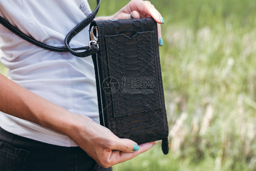 年轻女手持时髦的奢侈品蛇皮松手提包高清图片下载-正版图片505753217-摄图网