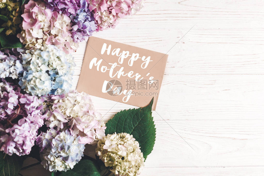 纸质贺卡上的母亲节快乐文字标志和质朴的白色木桌上高清图片下载-正版图片505806937-摄图网