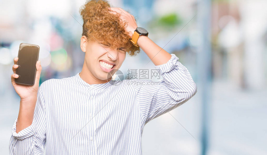 显示智能手机屏幕的英俊年轻男子头部压力很大高清图片下载-正版图片505840368-摄图网