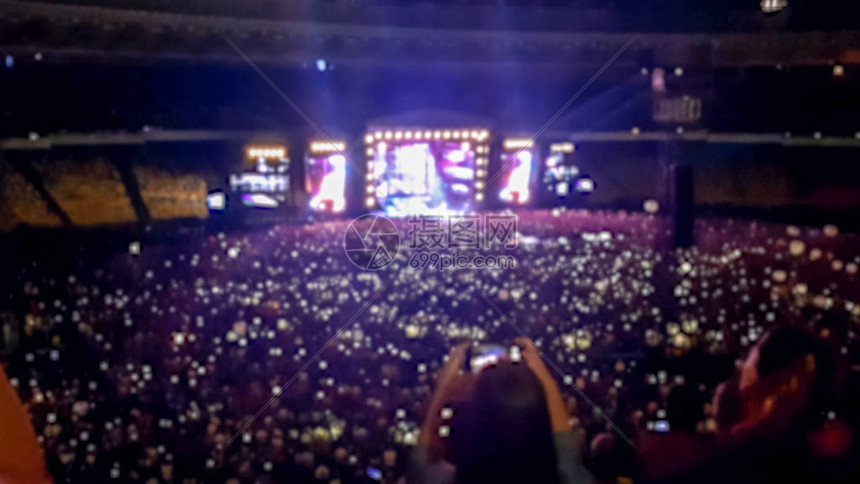 人们在大体育场的音乐节上聆听和观看大型摇滚音乐会的散焦图像晚上坐在看台上的粉丝群用光束和激高清图片下载-正版图片506072965-摄图网