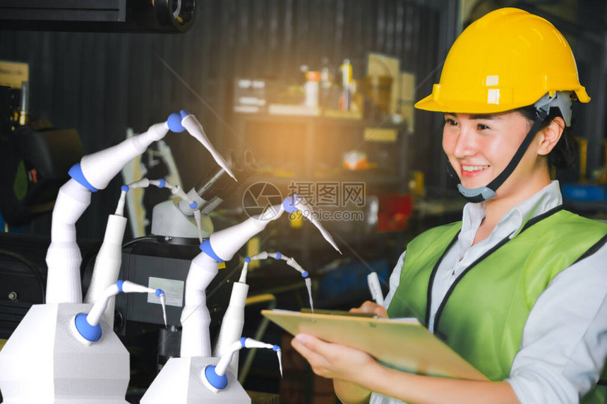 亚洲女工程师工厂检查与机器人AI机器ssist生产工程师在工业中她戴着头盔女在工业中工作金属制品控制高清图片下载-正版图片506231680-摄图网