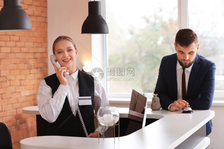 年轻女接待员在旅馆办公桌上高清图片下载-正版图片506377488-摄图网