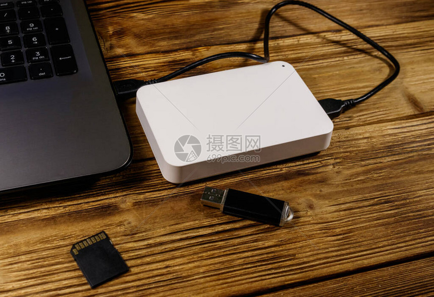外部HDD与膝上型计算机SD记忆卡和木制桌上US高清图片下载-正版图片506446587-摄图网
