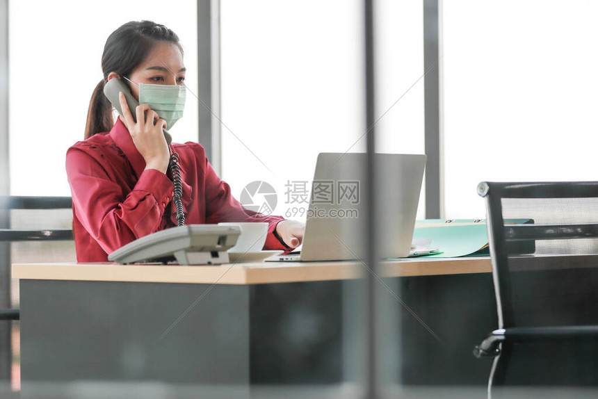 女员工作并在她的脸上戴外科卫生口罩高清图片下载 正版图片506489286 摄图网