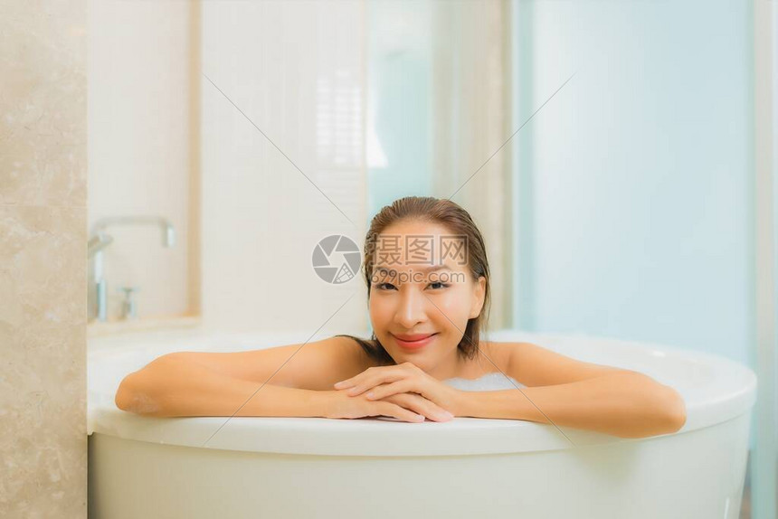 在浴室的浴缸里放松笑容内地洗手间里的清净美丽年轻的高清图片下载 正版图片506710913 摄图网