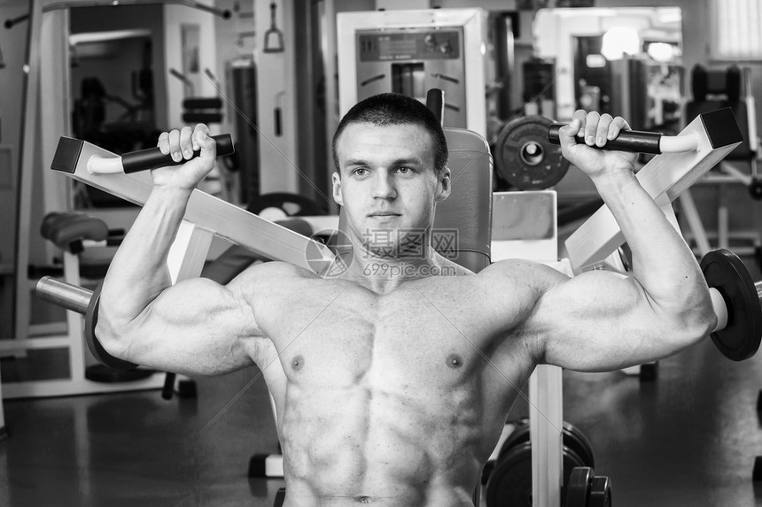 健身房里的肌肉男锻炼手臂肌肉在模拟器上训练在他的身高清图片下载-正版图片507260054-摄图网