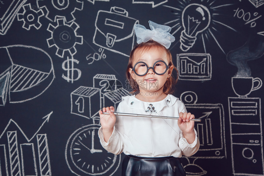 戴眼镜的小聪明女孩拿着指针在墙上画着照高清图片下载-正版图片507317783-摄图网