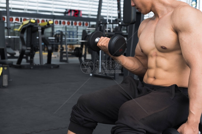 年轻人在健身房举哑铃健美男在健身中心锻炼运动的家伙在健高清图片下载-正版图片507425362-摄图网