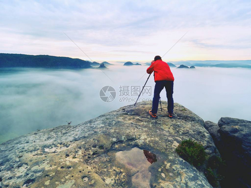 摄影师用取景器取景摄影爱好者在岩石山顶享受秋季大自然的作品梦幻般的风景高清图片下载-正版图片507429685-摄图网
